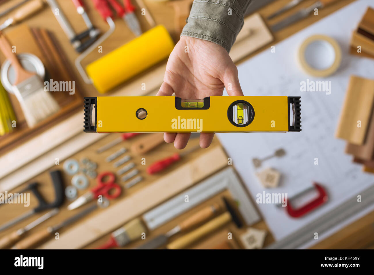 Male hands holding a level, work table with construction and repair ...