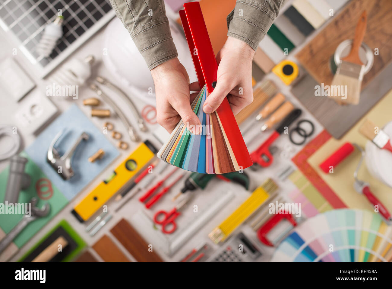 Male hands holding swatches and choosing the right color, work tools on ...