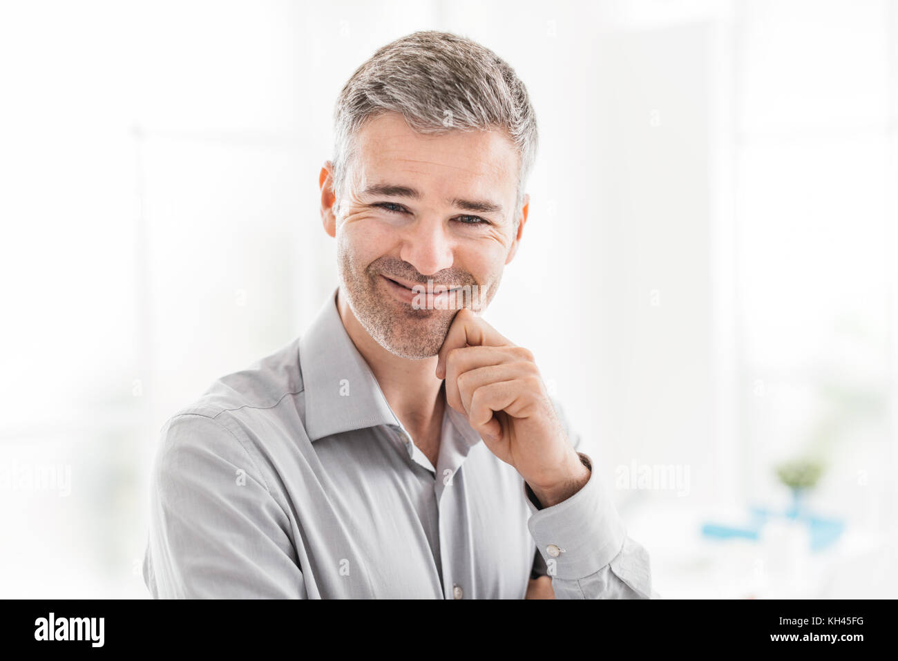 Confident smiling man posing in the office and smiling at camera Stock ...
