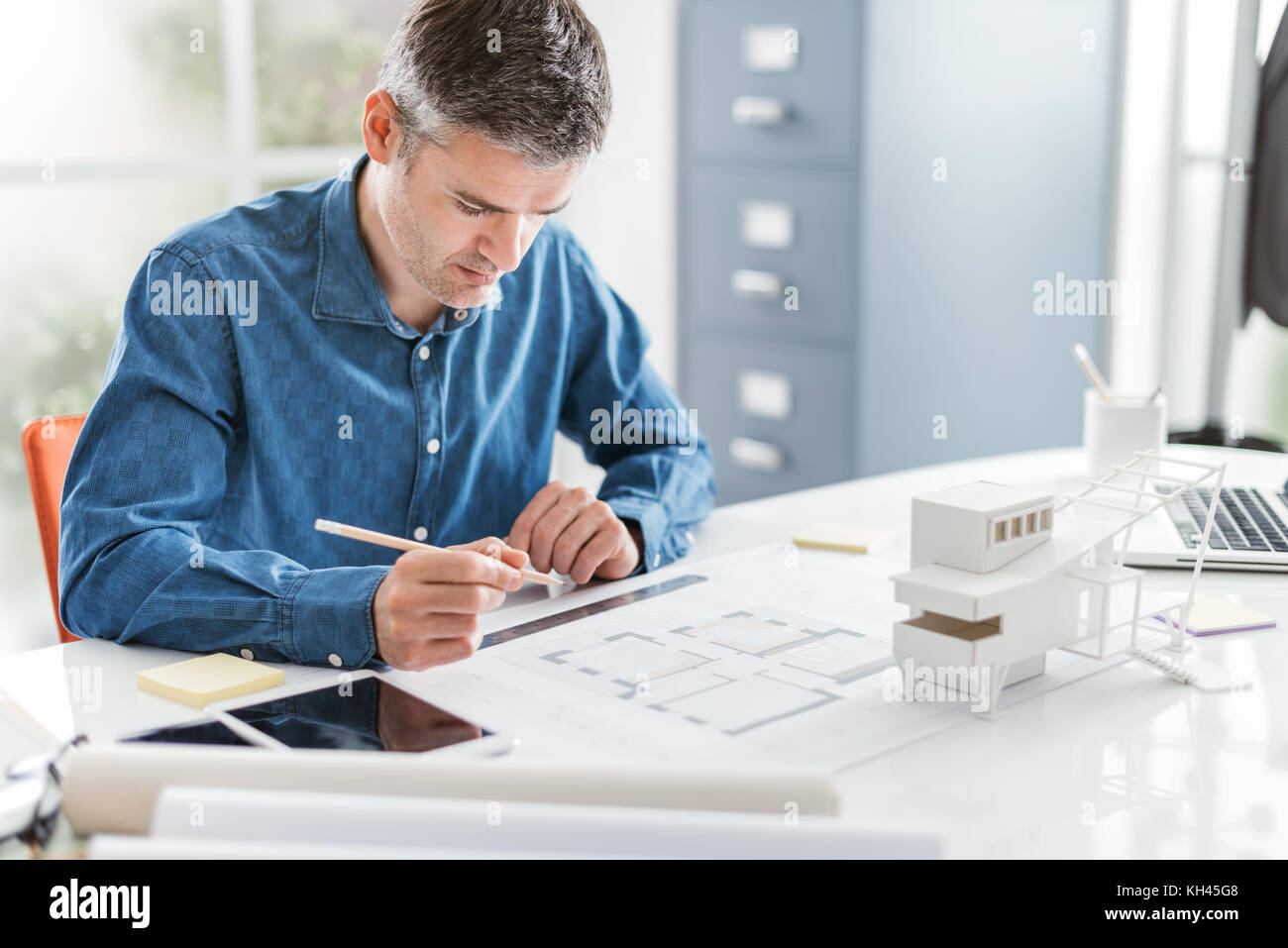 Professional architect working at office desk, he is drawing and making ...