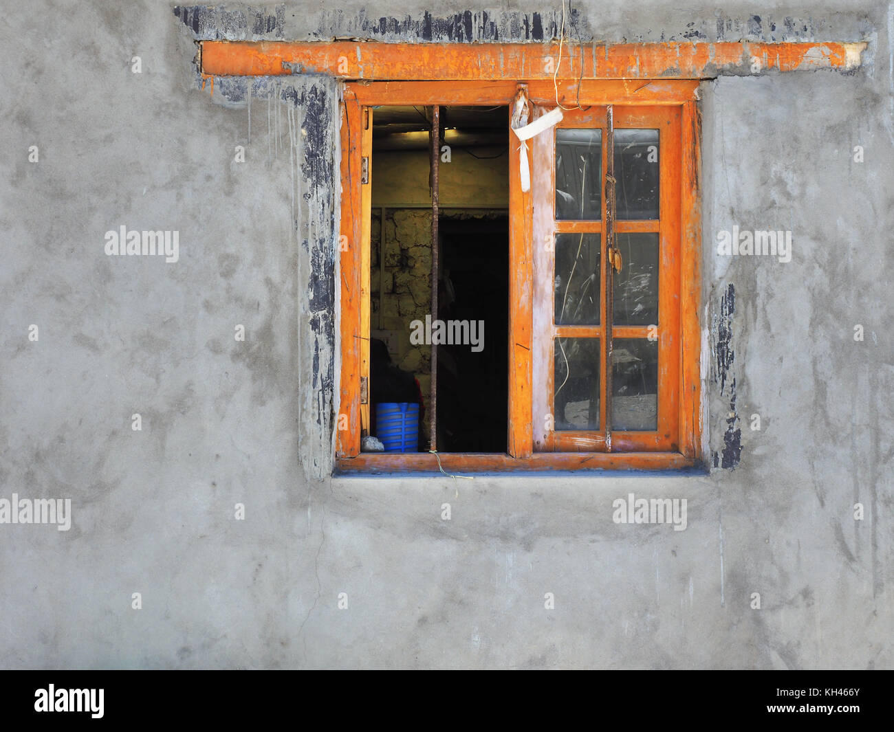 Orange window on a cement gray wall, wooden vintage frames and dirty ...