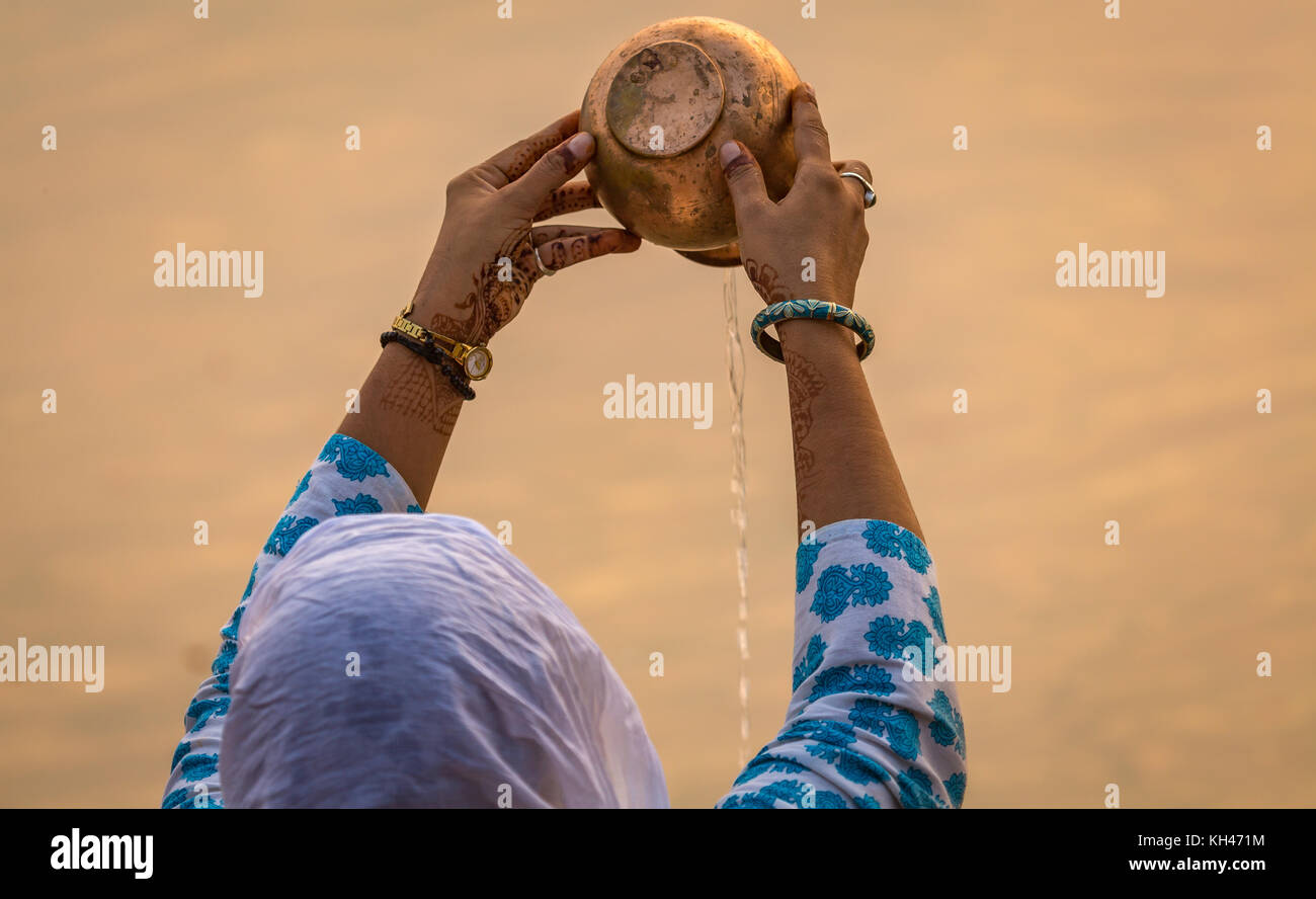 Hindu woman offering water to the Ganges river as part of a ritual at ...