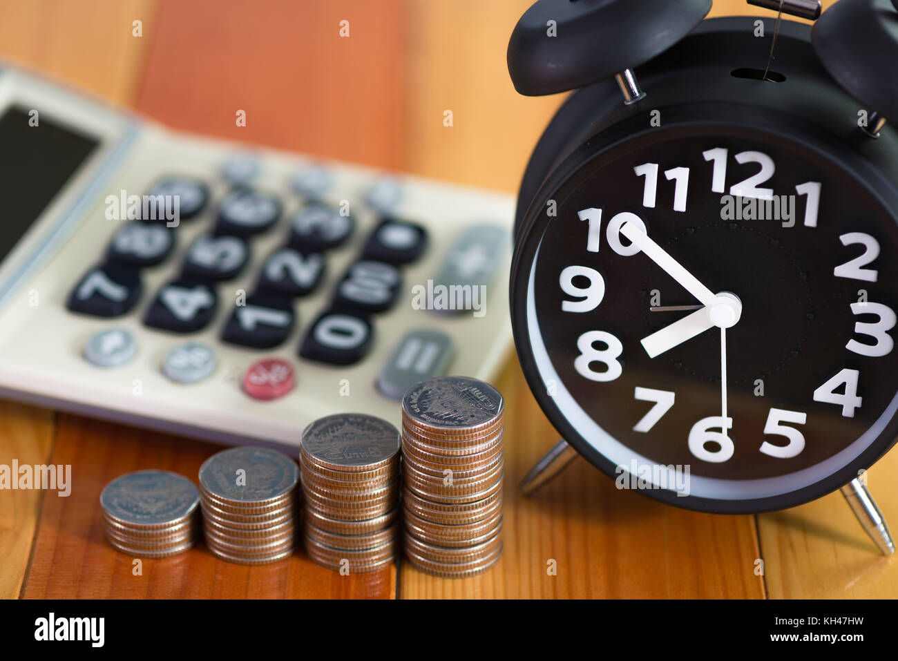 Alarm clock and step of coins stacks on working table, time for savings ...