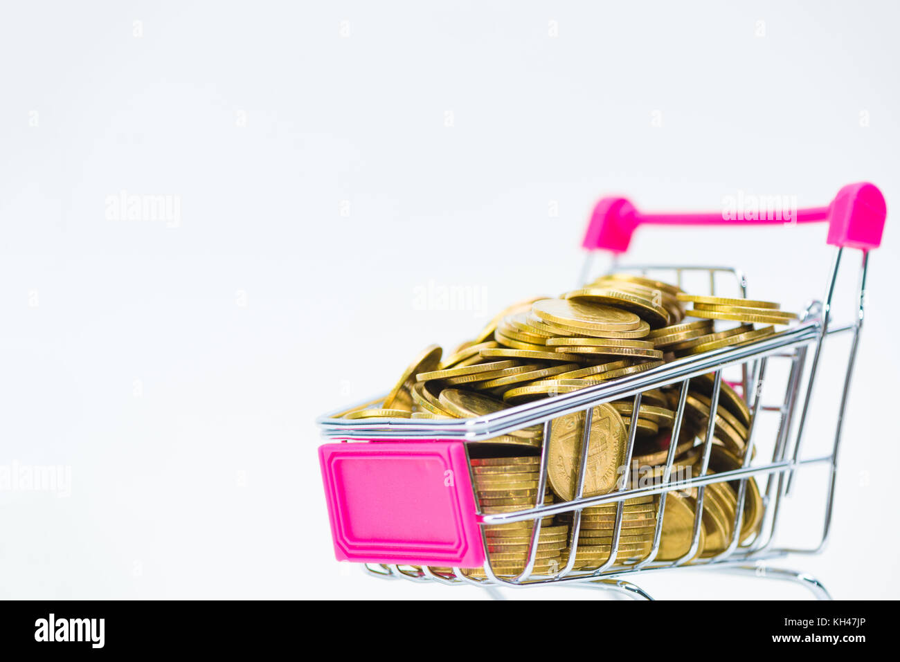 Stack of coins in shopping cart or supermarket trolley on white ...