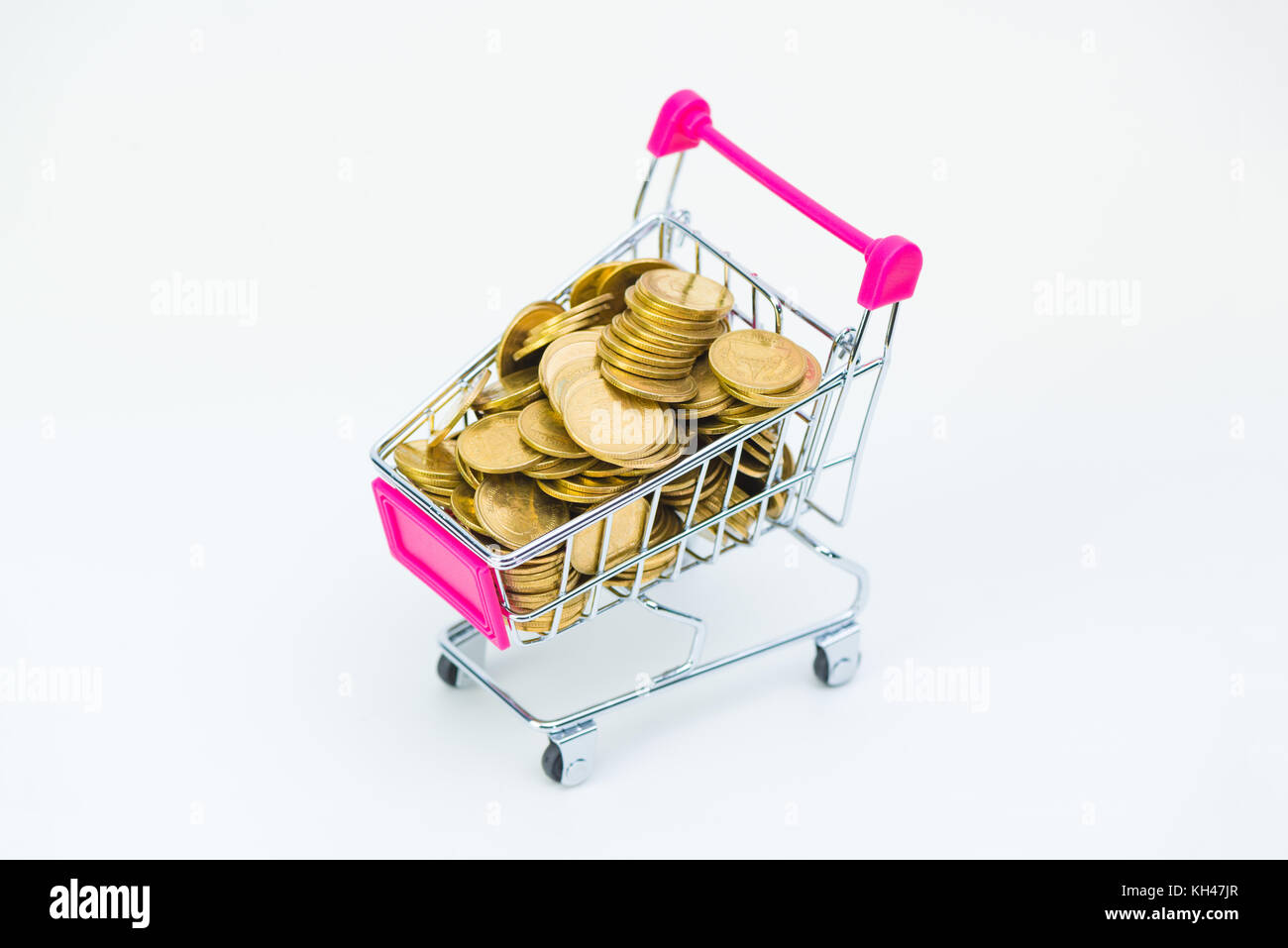 Stack of coins in shopping cart or supermarket trolley on white ...