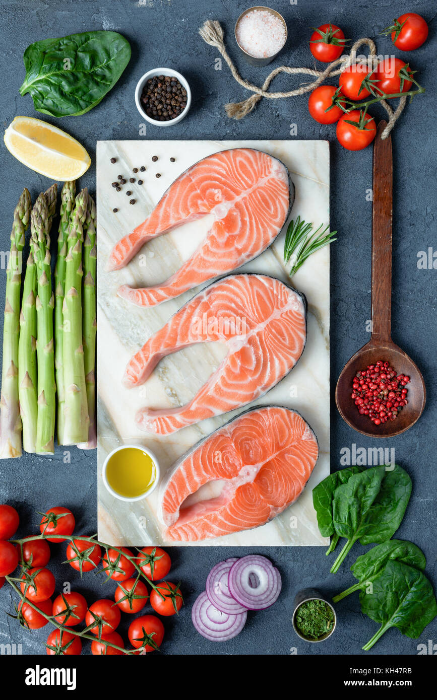 Salmon steaks, spices, vegetables, herbs and cooking condiments. Table ...