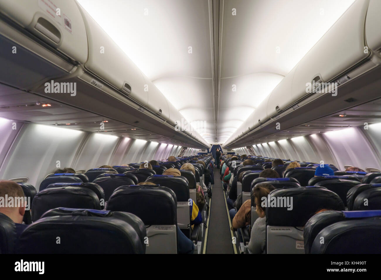 Interior of airplane with passengers on seats Stock Photo - Alamy