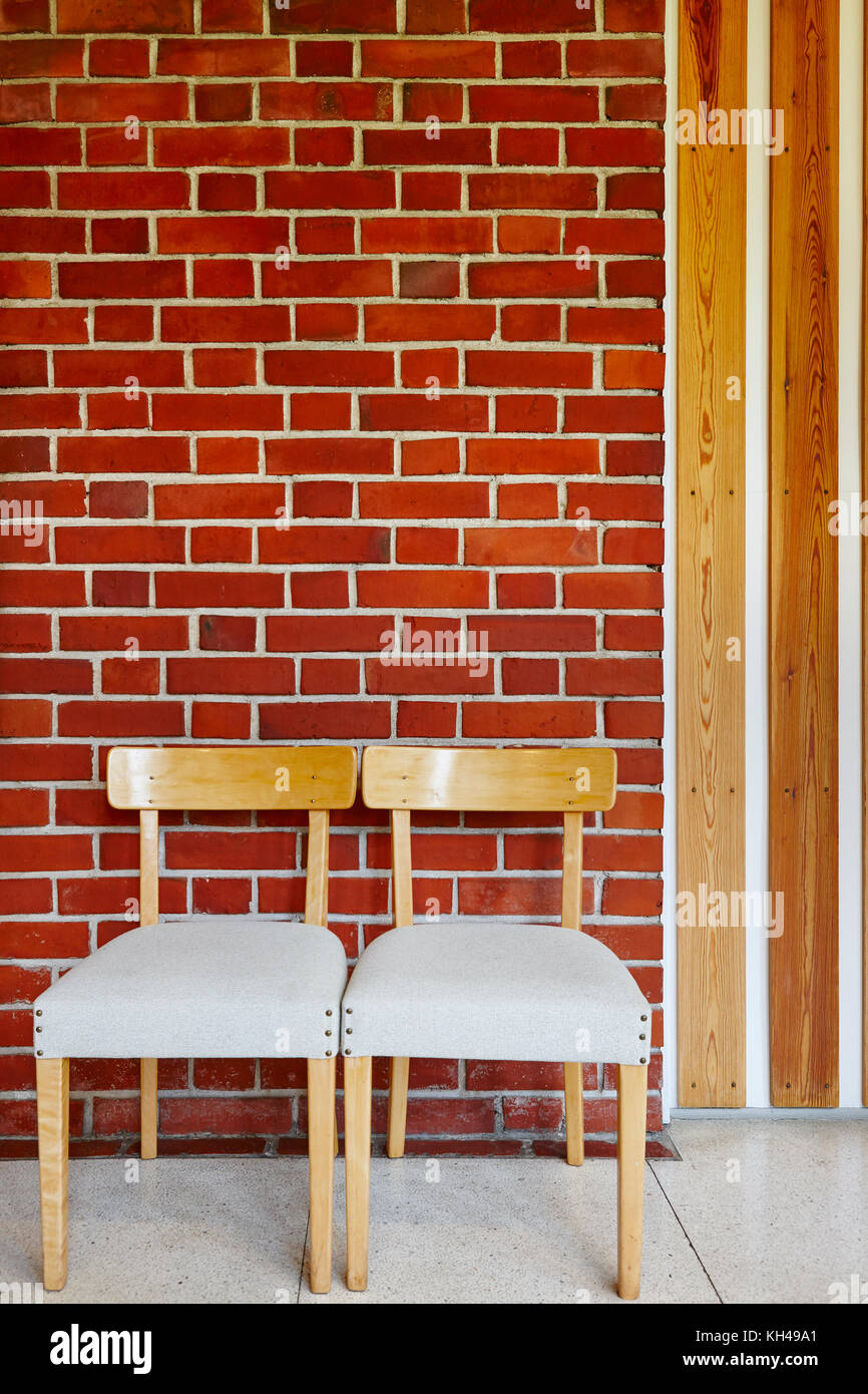 Building interior with wooden chairs and red brick wall. Vertical Stock ...