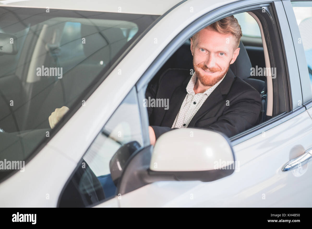 Happy man buying new car in auto showroom Stock Photo - Alamy