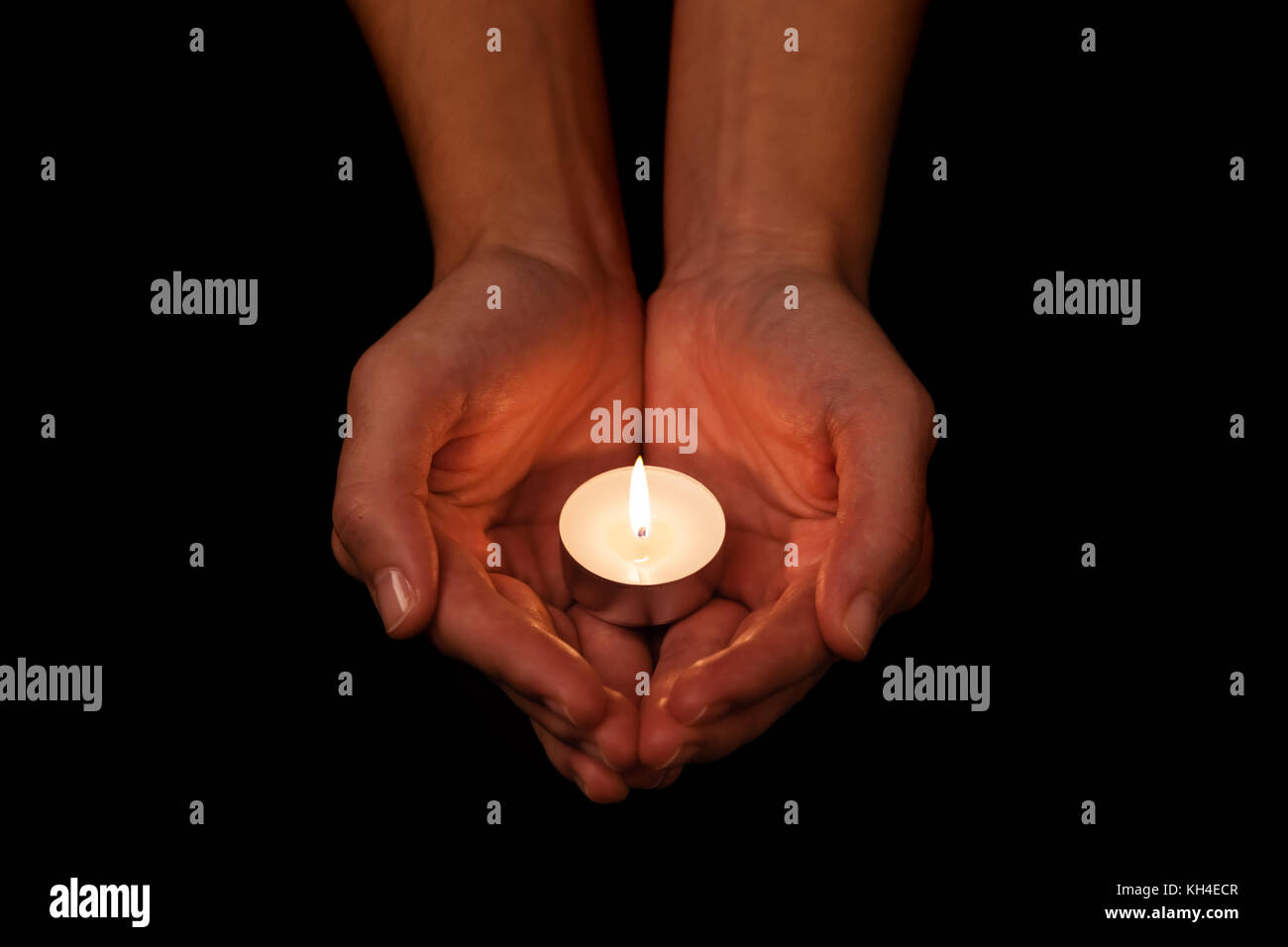 Hands holding and protecting lit or burning candle candlelight on ...