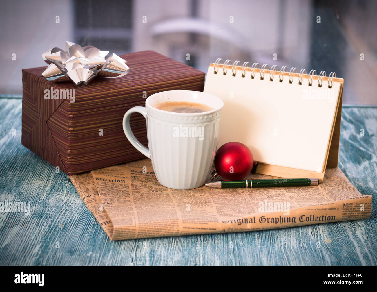 Festive still life with box, cup, ball, newspaper, notebook Stock Photo ...