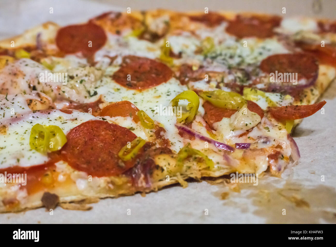 Appetizing slice of pizza with salami and hot pepper macro Stock Photo ...