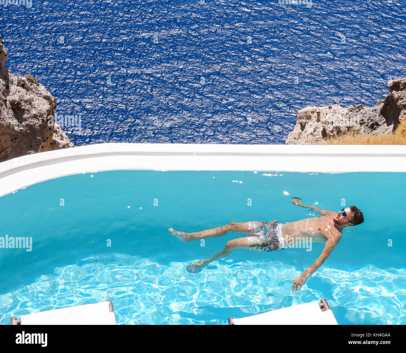 High angle view from above of a man flooting in a swimming pool at a ...