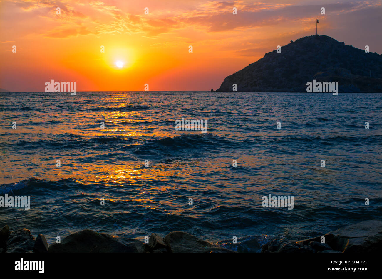 Dramatic orange sunset over the Turkish beach of Gumusluk Stock Photo ...