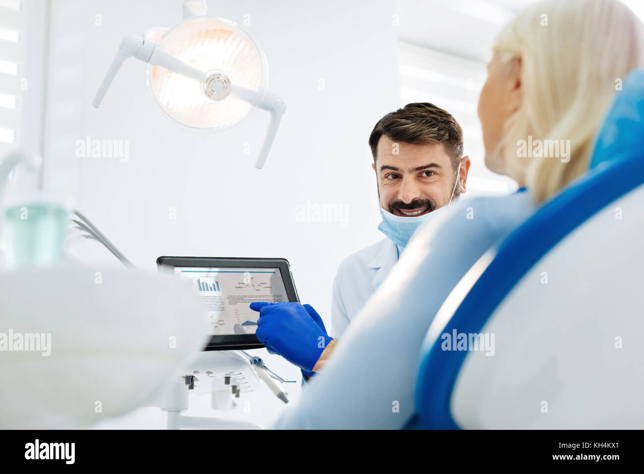 Smiling stomatologist pointing at the tablet screen Stock Photo - Alamy