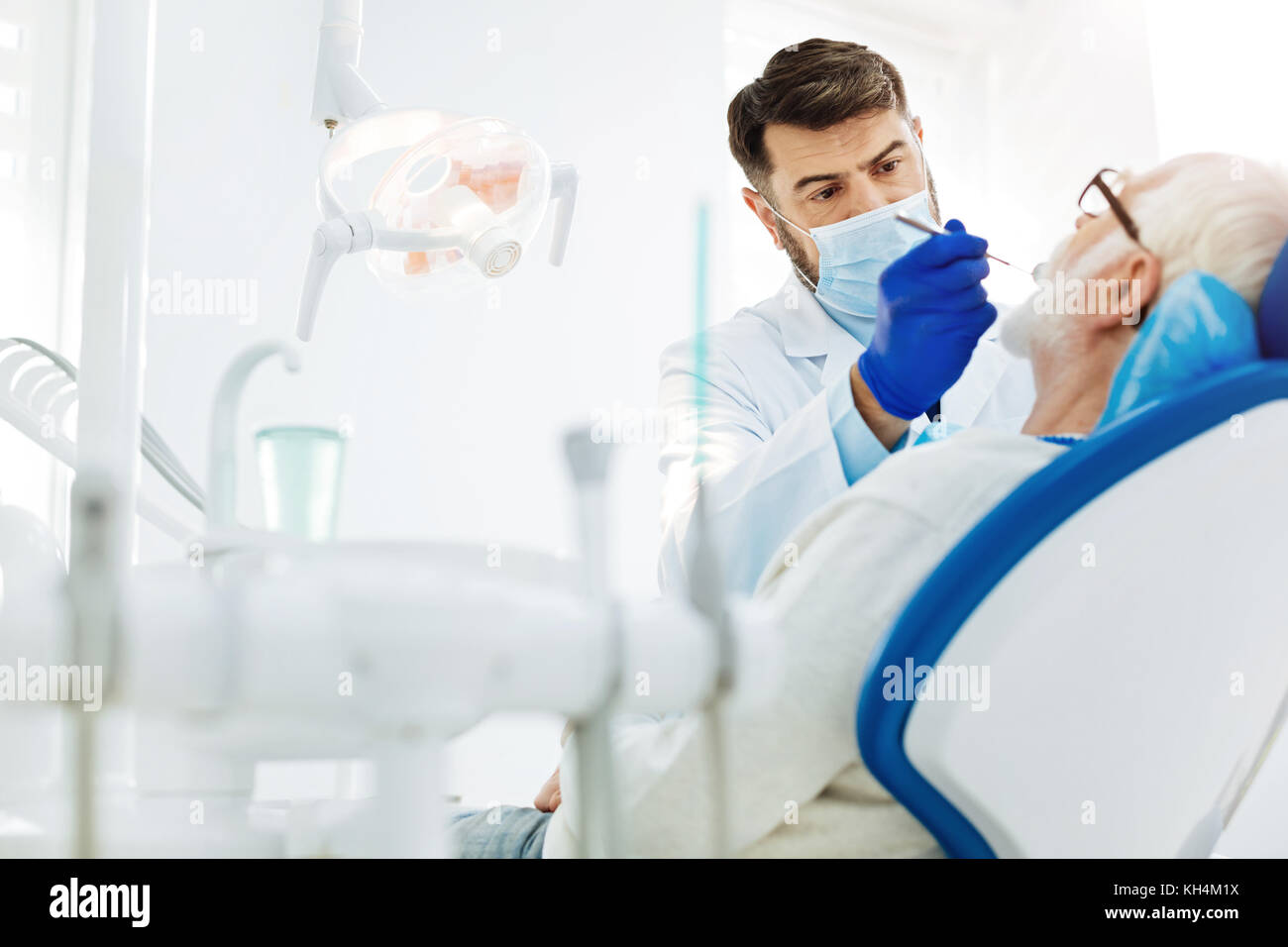 Concentrated dental surgeon curing patients teeth Stock Photo - Alamy
