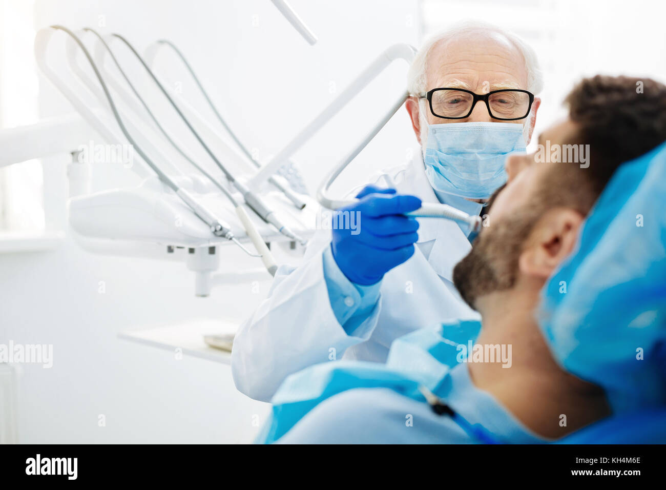 Concentrated dentist in the process of curing teeth Stock Photo - Alamy