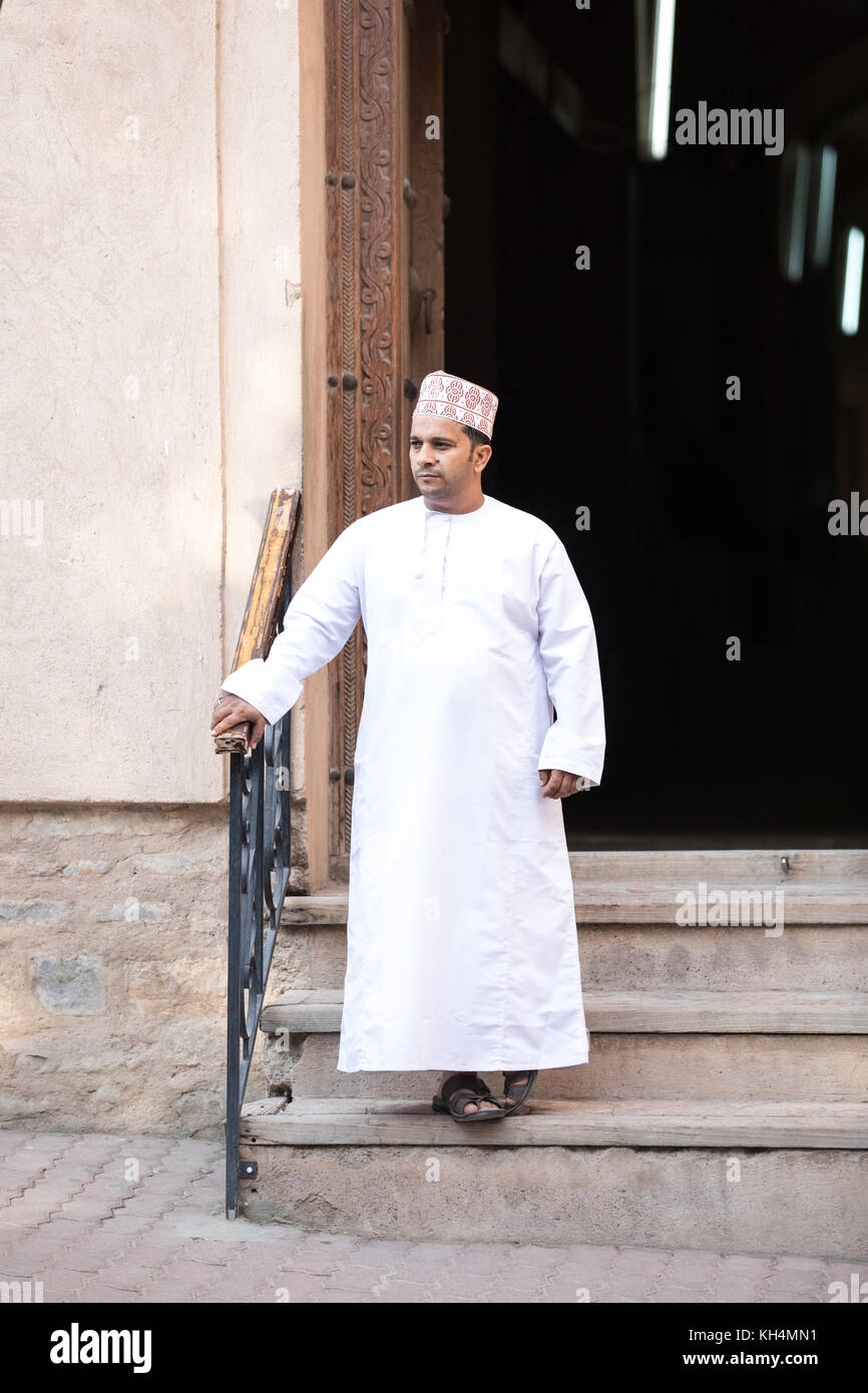 Omani man in a traditional outfit standing on the edge of a staircase ...
