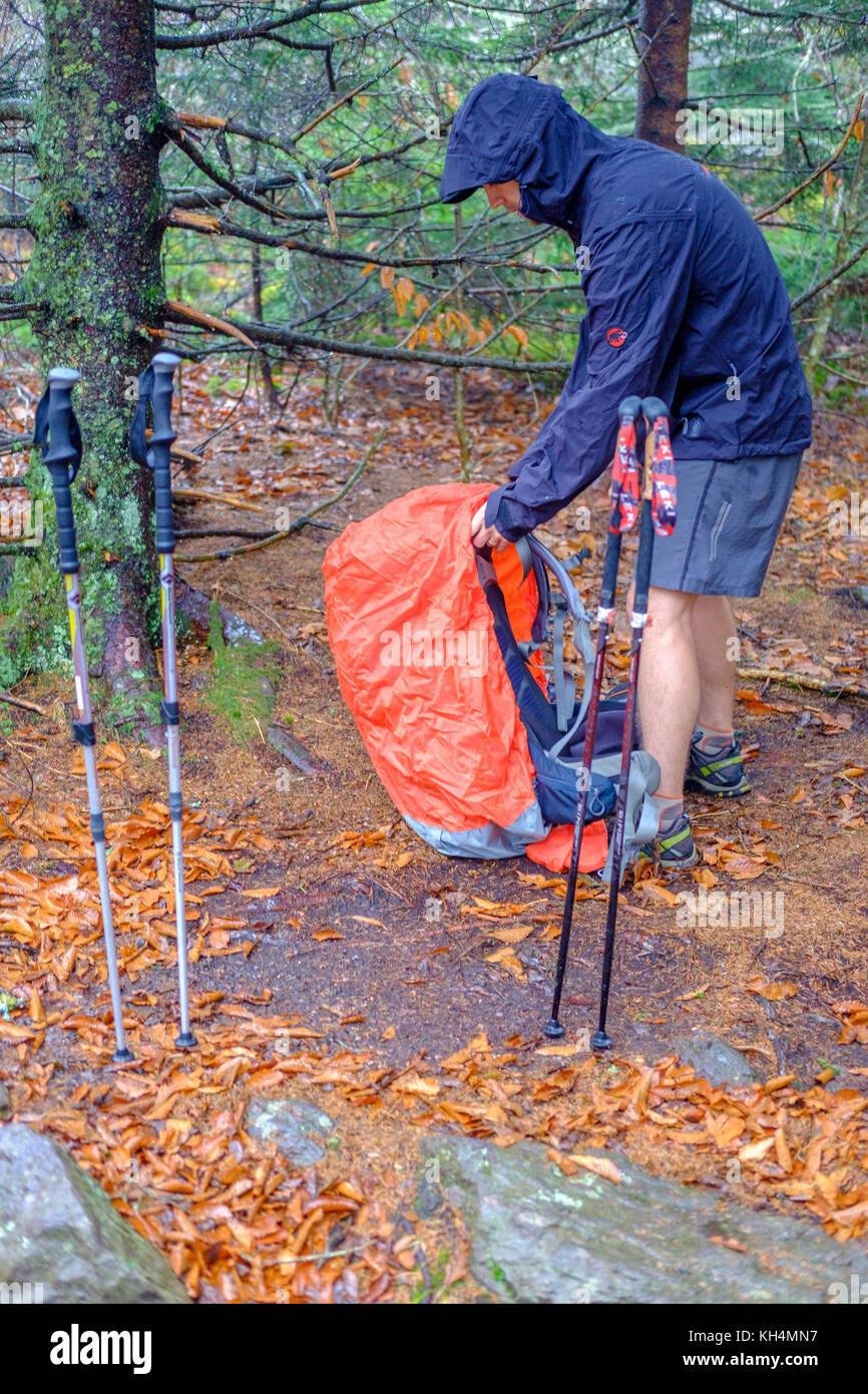 Backpacker gets ready for the rain Stock Photo - Alamy