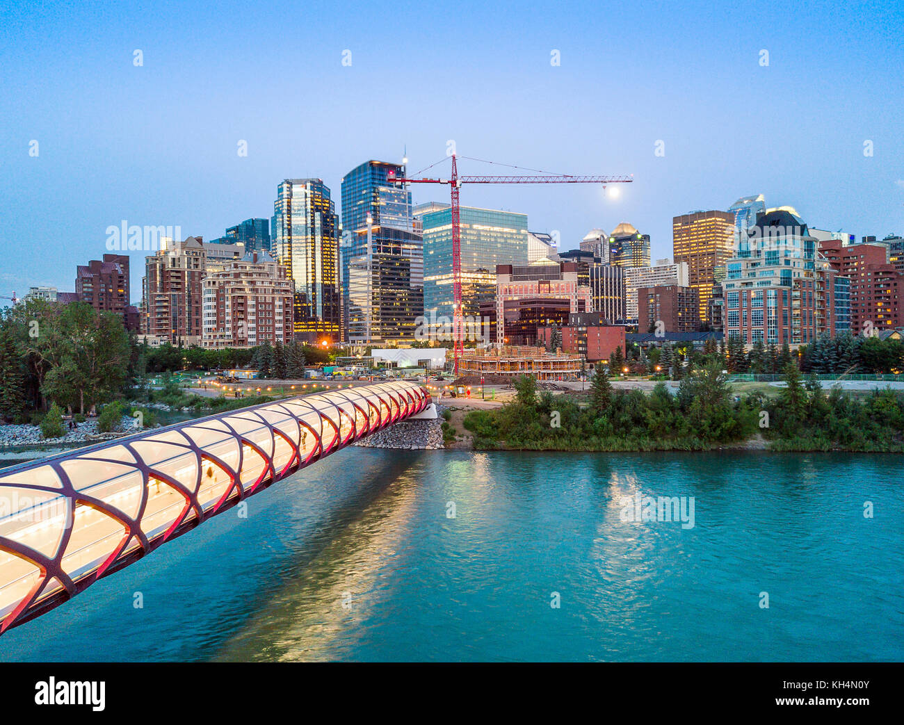 Calgary downtown with iluminated Peace Bridge and full moon, Alberta ...