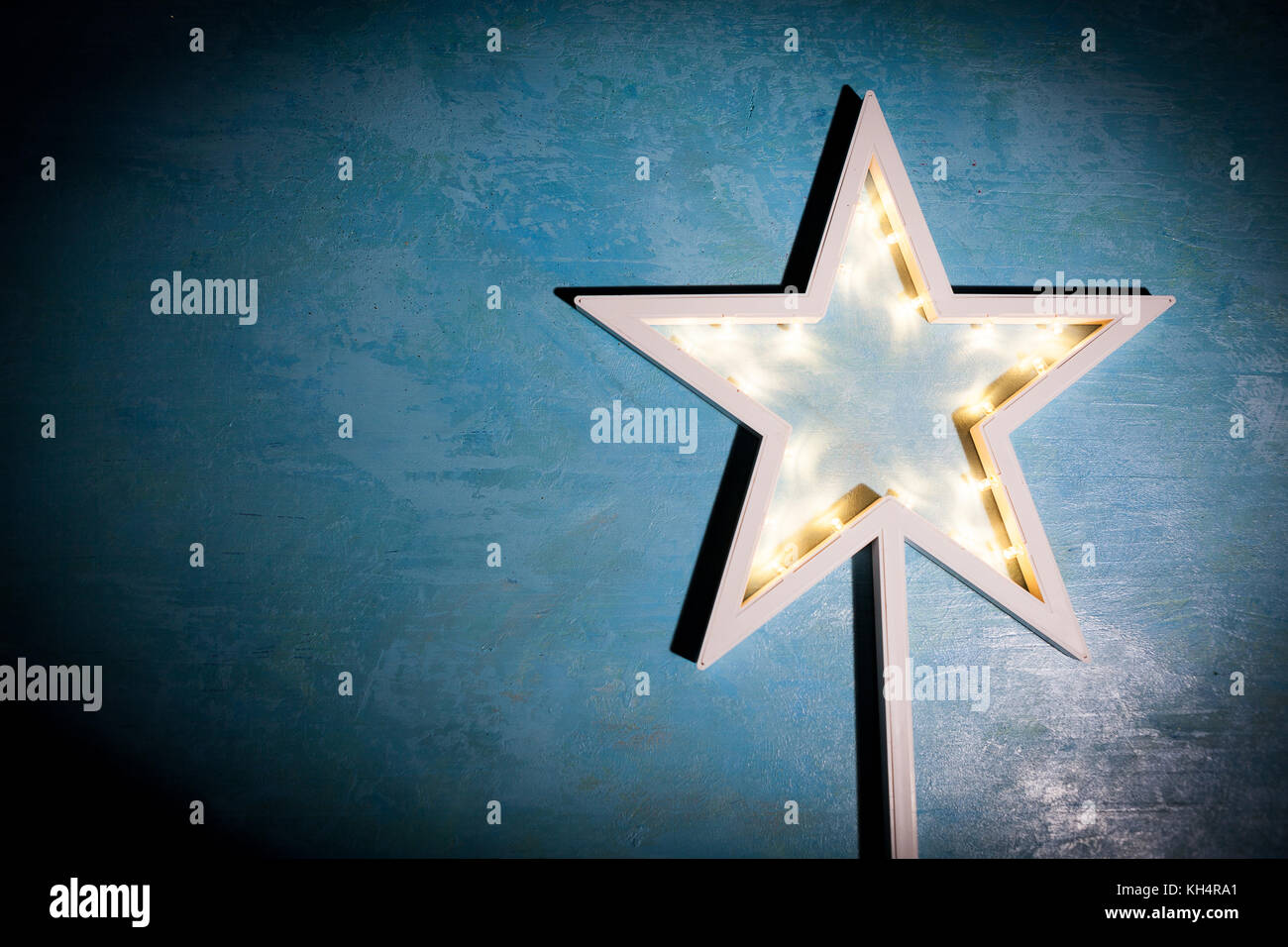 White Christmas star with yellow lights on blue background Stock Photo ...