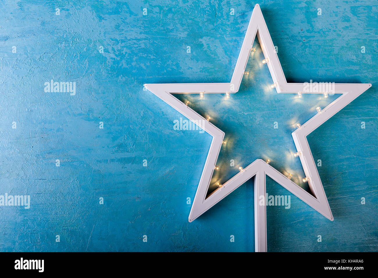 White Christmas star with yellow lights on blue background Stock Photo ...