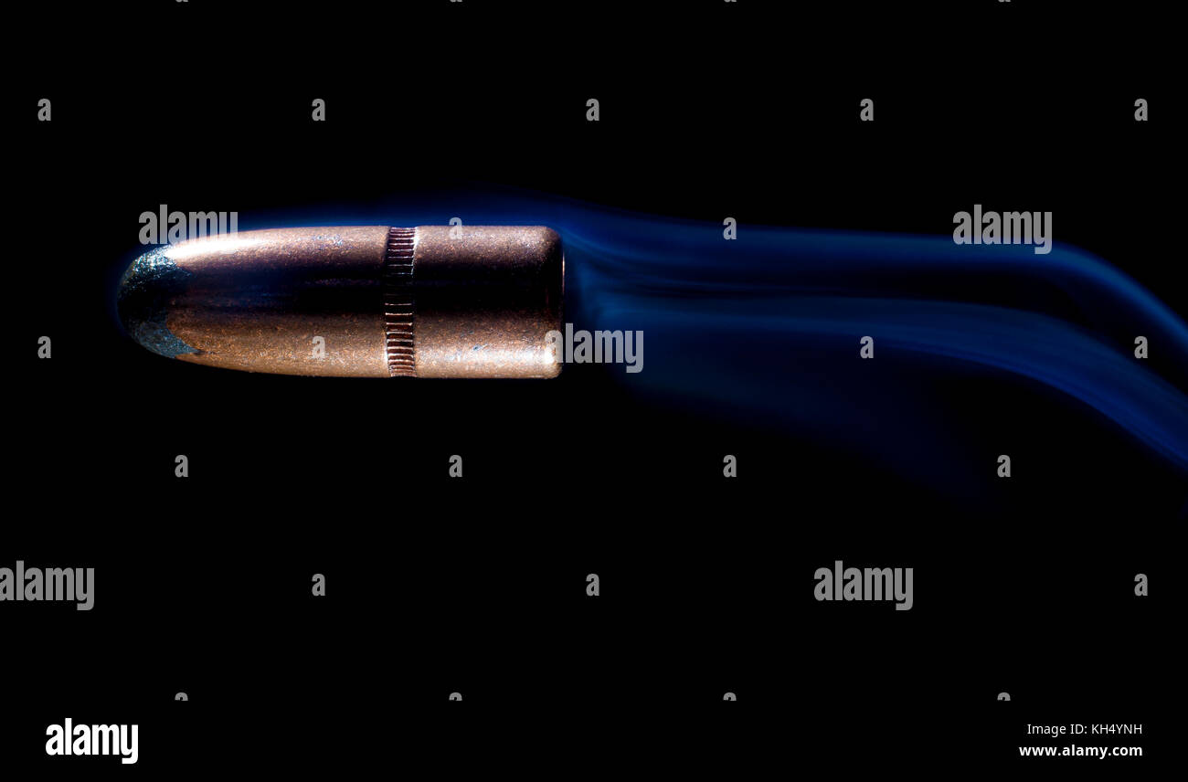 Bullet with copper coating and blue smoke behind Stock Photo - Alamy