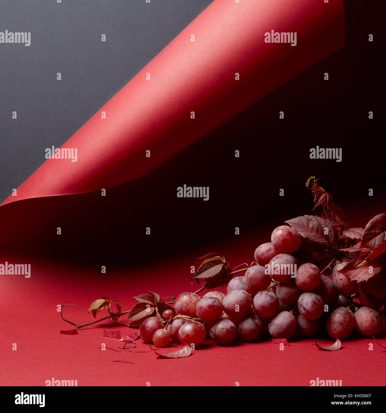 ripe fresh red grapes on a red background Stock Photo - Alamy