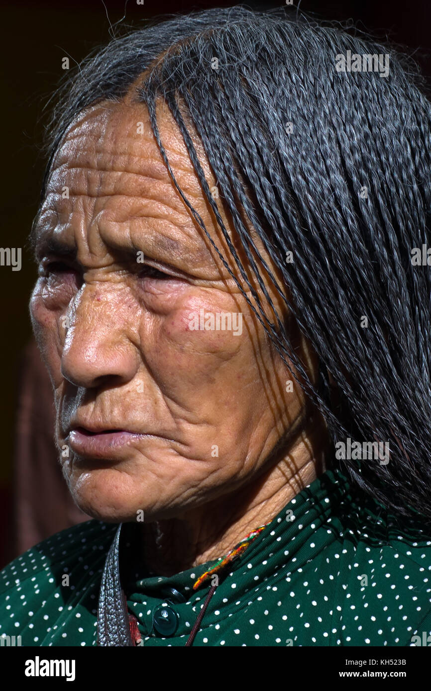 Tibetan pilgrim woman with braided hair in Rongwo monastery, Tongren ...