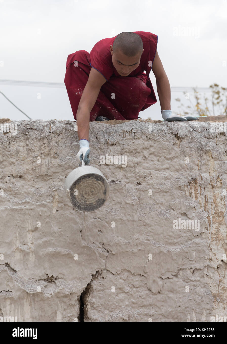 tibetan Monk painting the wall of a temple in Rongwo monastery, Tongren ...