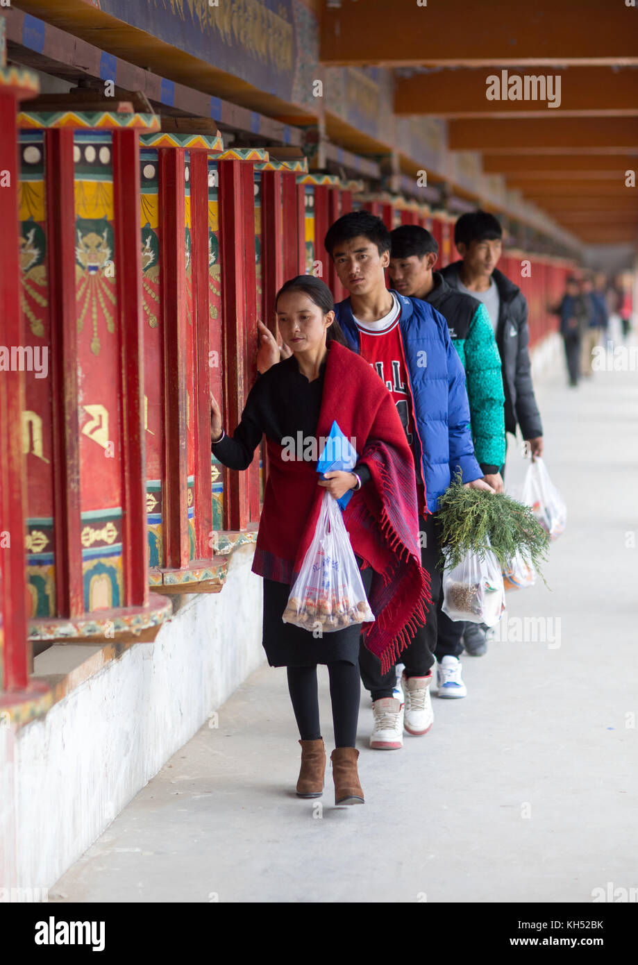 Tibetan pilgrims turning prayer wheels in a Rongwo monastery, Tongren ...