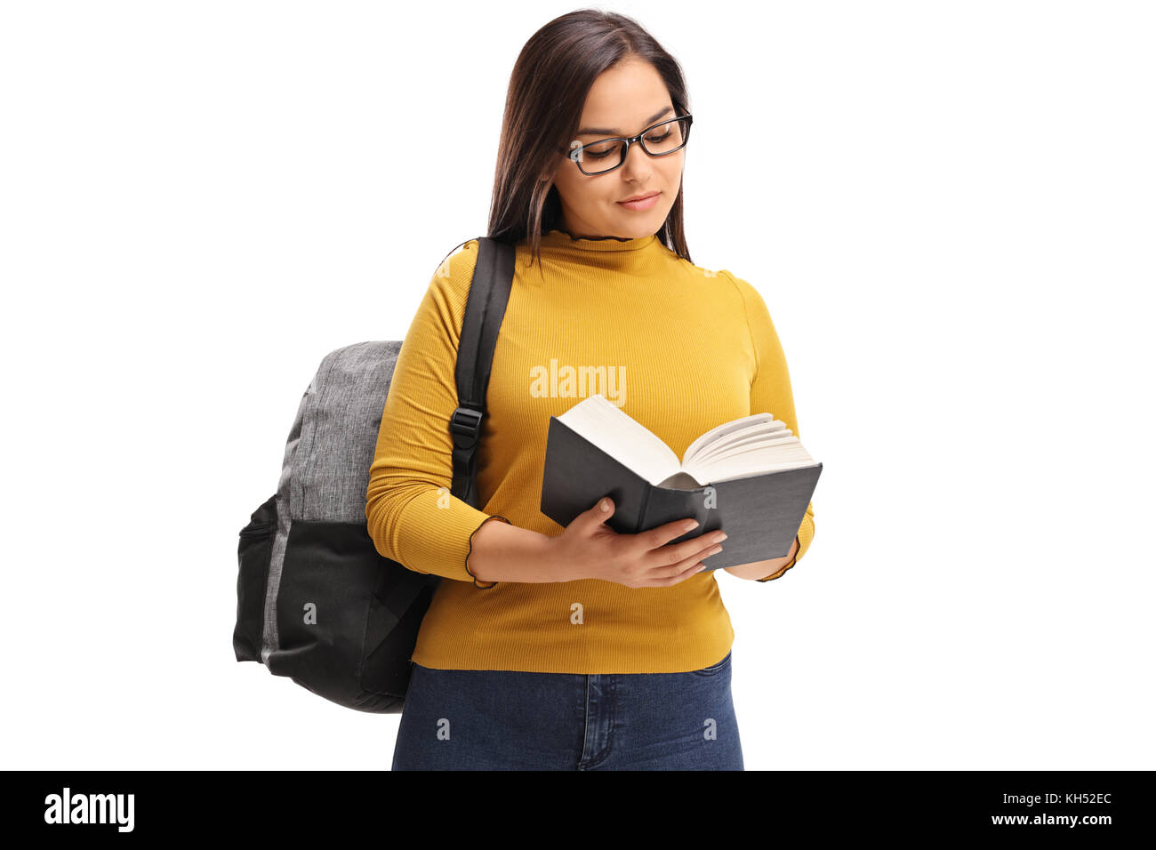 Female teen student with a backpack reading a book isolated on white ...