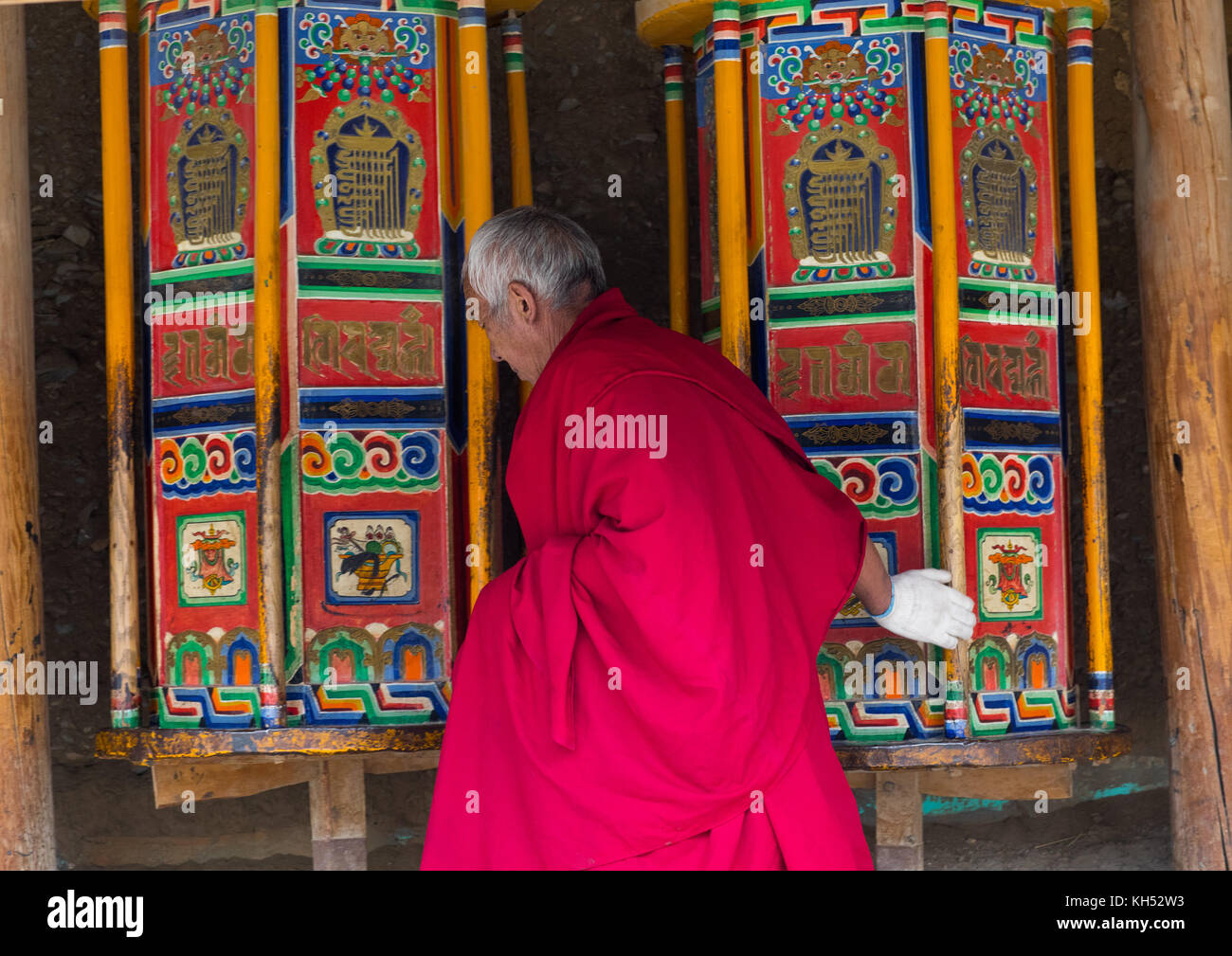 Tibetan monk turning huge prayer wheels in Labrang monastery, Gansu ...