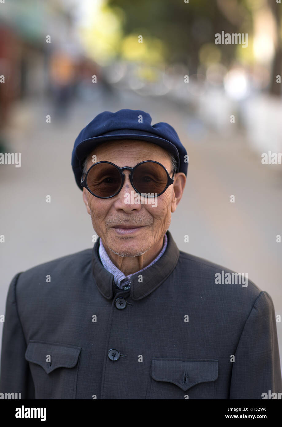 Old man with traditional sunglasses and cap, Gansu province, Linxia ...