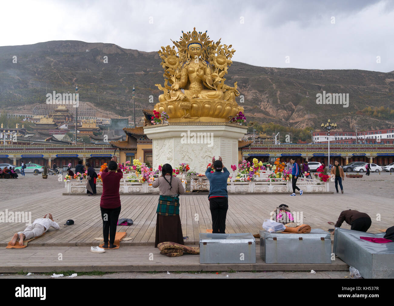 Tibetan people praying in front of the statue of the buddhist goddess ...