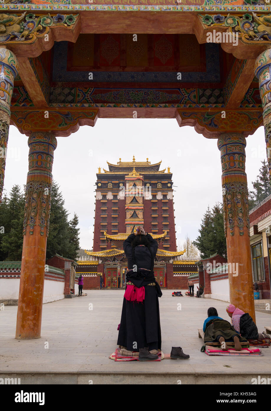 Tibetan pilgrims praying and prostrating in front of Hezuo monastery ...