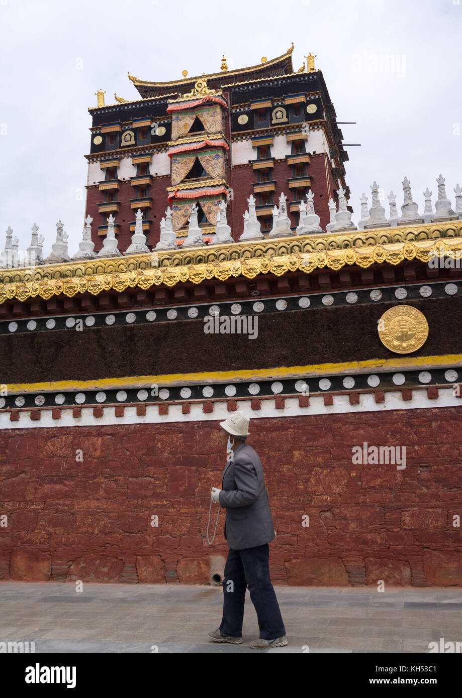 Tibetan pilgrim doing kora around Hezuo monastery and its milarepa ...