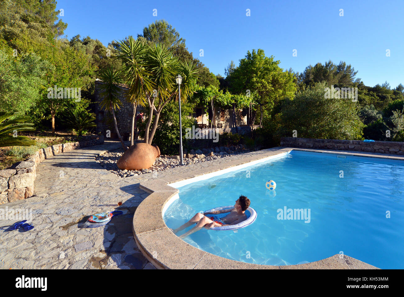 Teenage boy jumping into a private villa swimming pool Stock Photo - Alamy