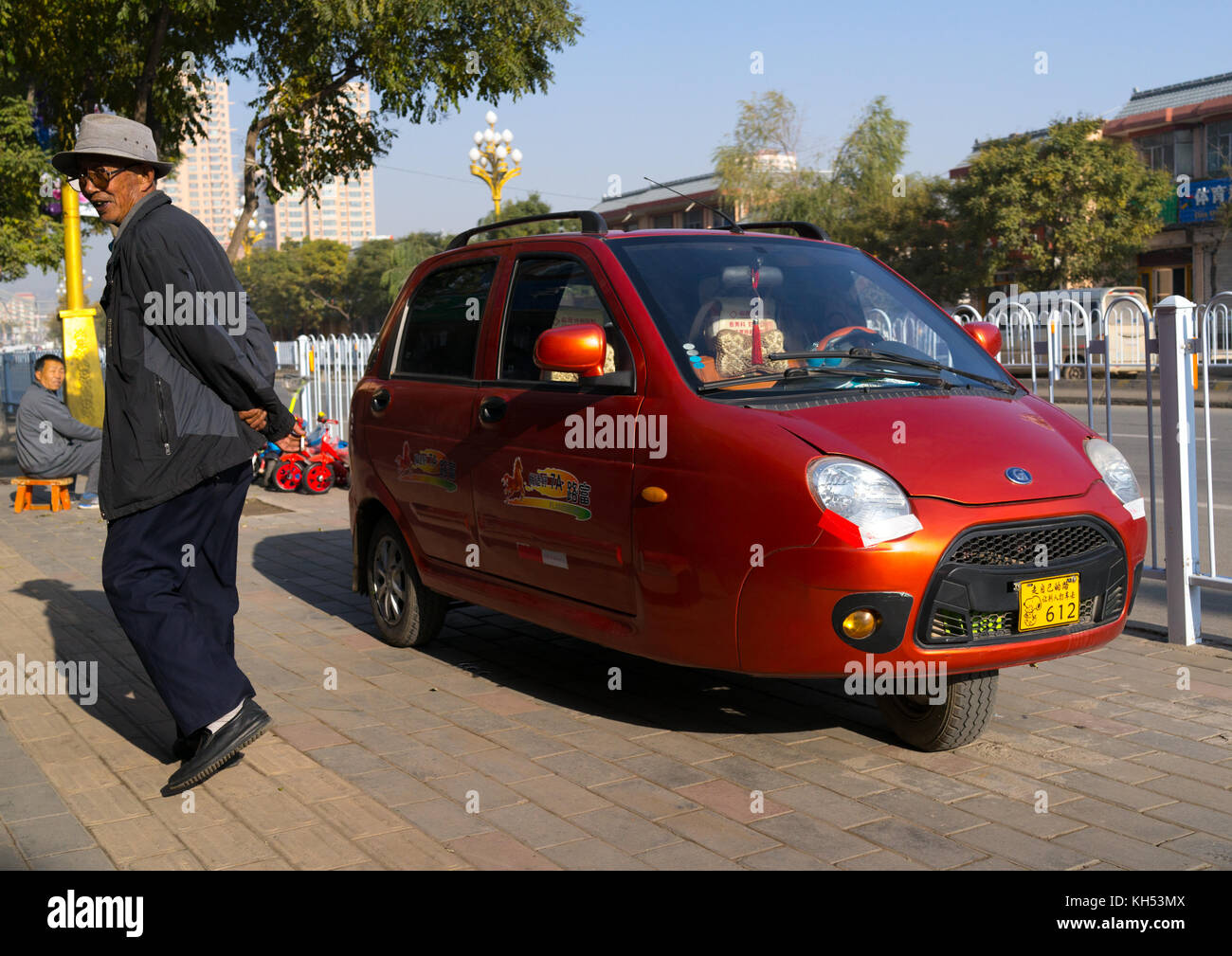 Cute small three-wheeled red chinese taxi in the street, Gansu province ...
