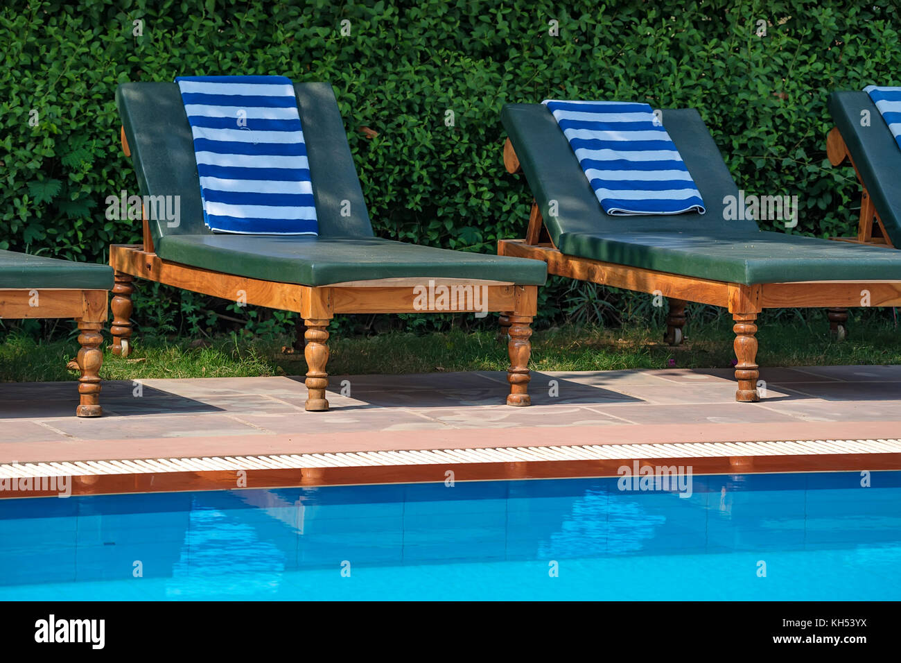 Deck chairs near the swimming pool Stock Photo - Alamy