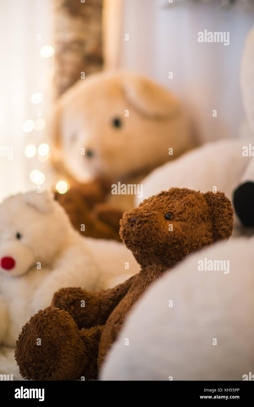 brown teddy bears lays inside the arms of white stuffted bears with ...