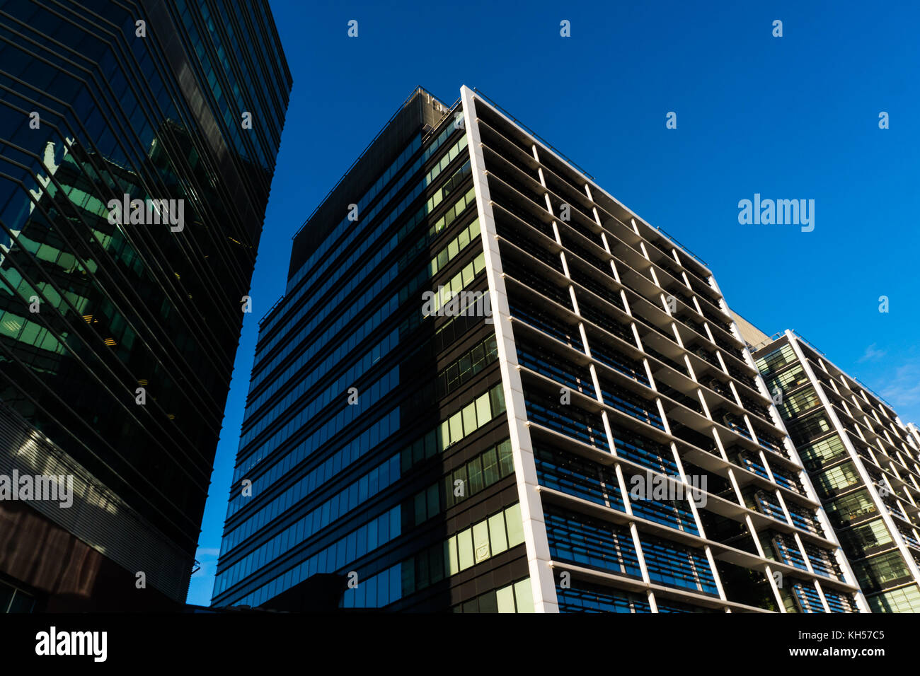 Tall building's glass window reflect daylight in town Stock Photo - Alamy