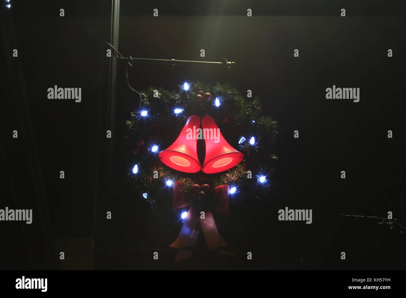 A shot of Red Christmas Bells with a Wreath with lights thats bright ...