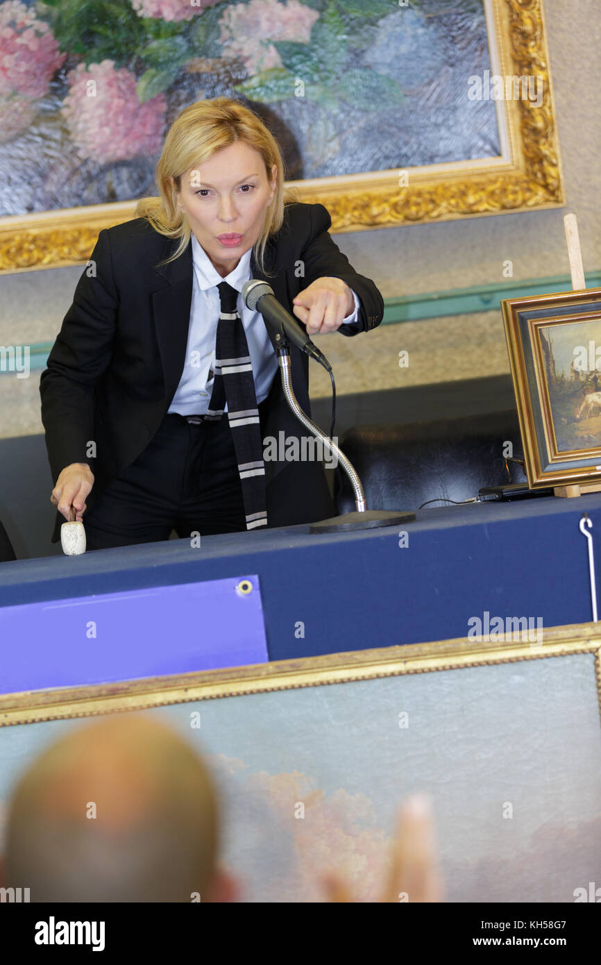 woman auctioneer selling to a bidder Stock Photo - Alamy