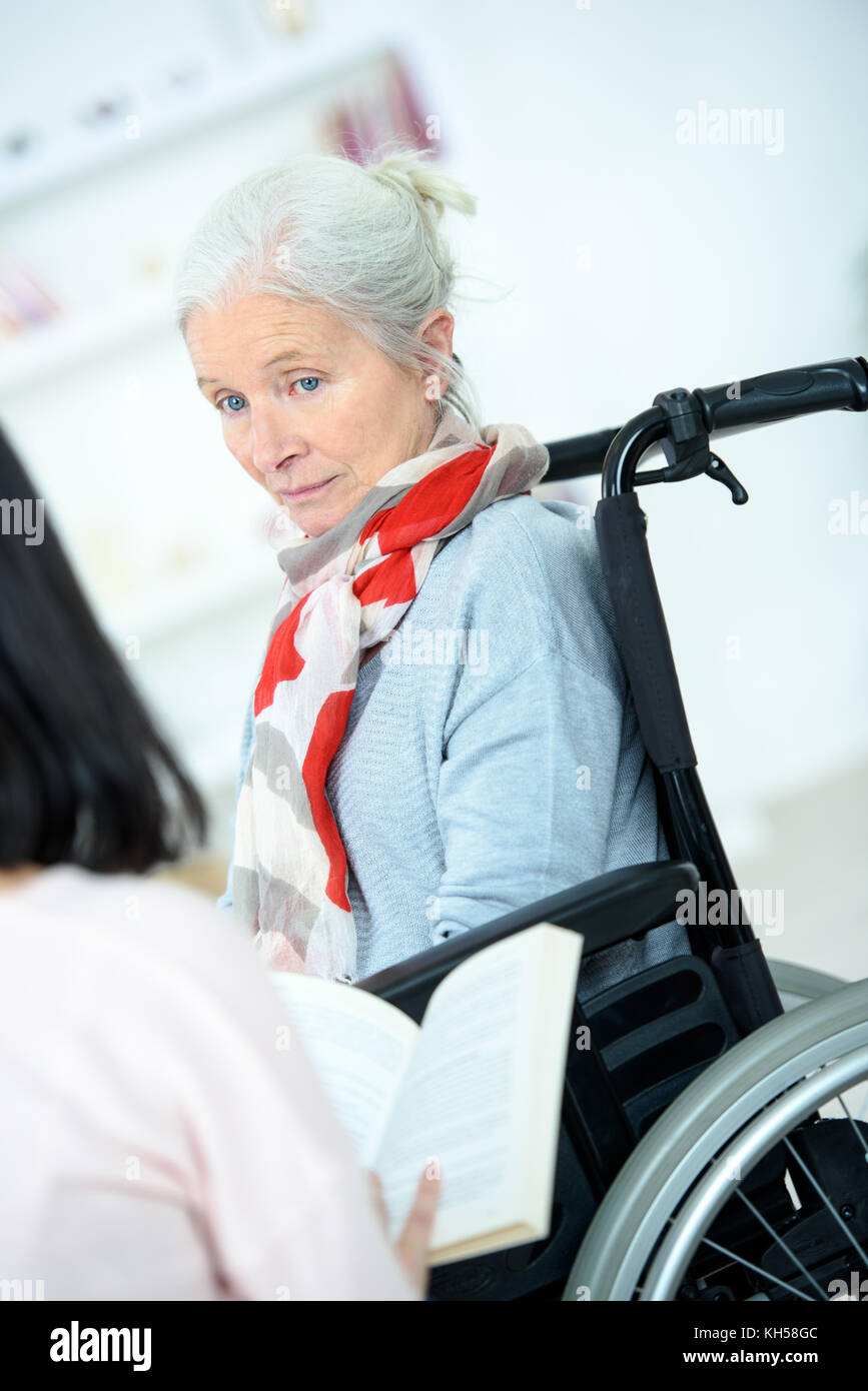 Helping senior woman to read Stock Photo - Alamy