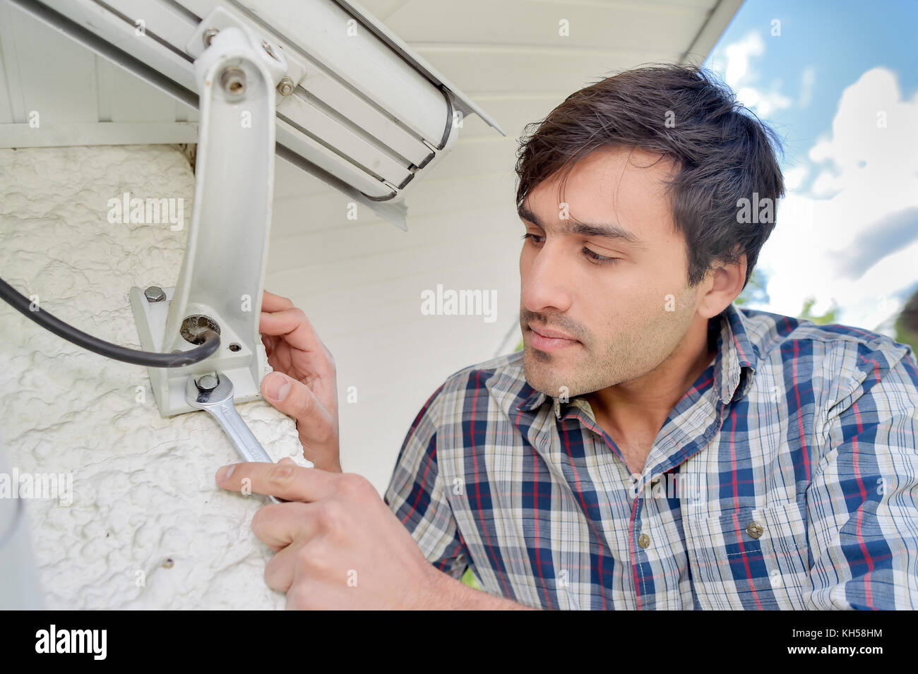 Cautious man installing a security camera Stock Photo - Alamy