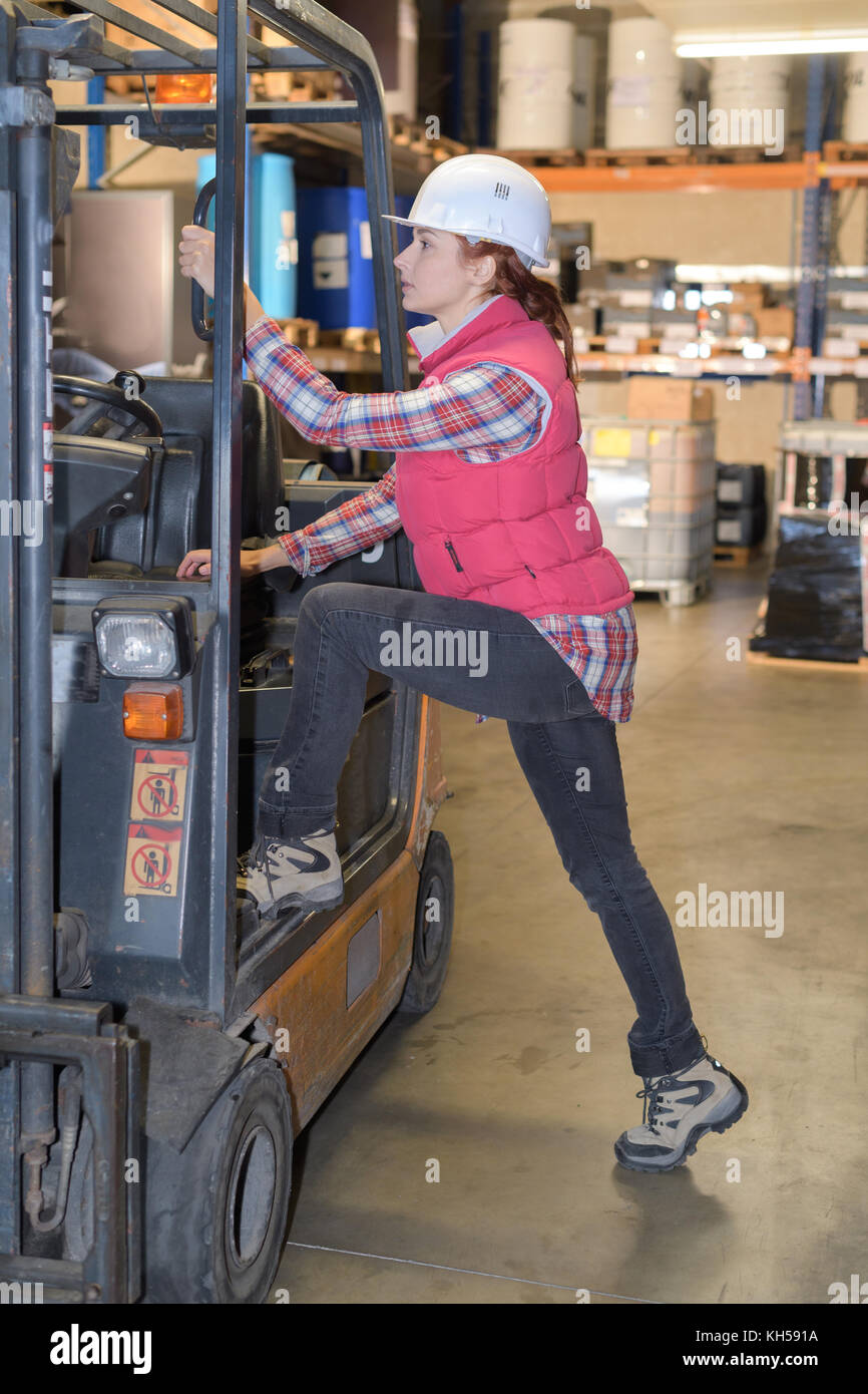 female worker climbing into cab of forklift truck Stock Photo - Alamy