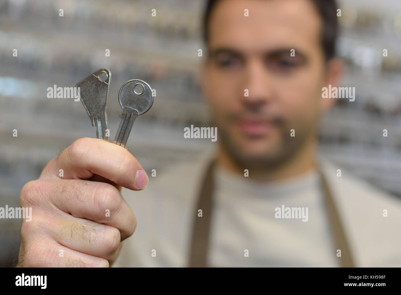 Man holding forward two keys Stock Photo - Alamy
