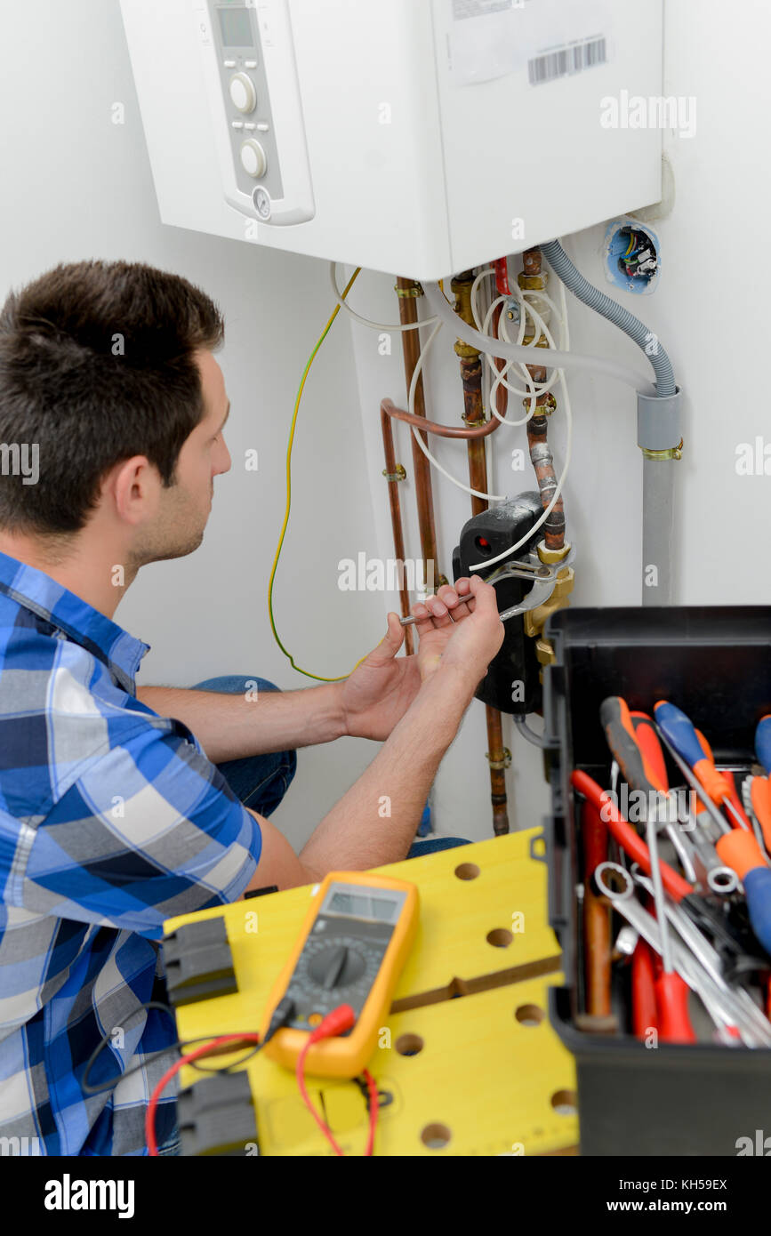 Man fitting boiler Stock Photo - Alamy