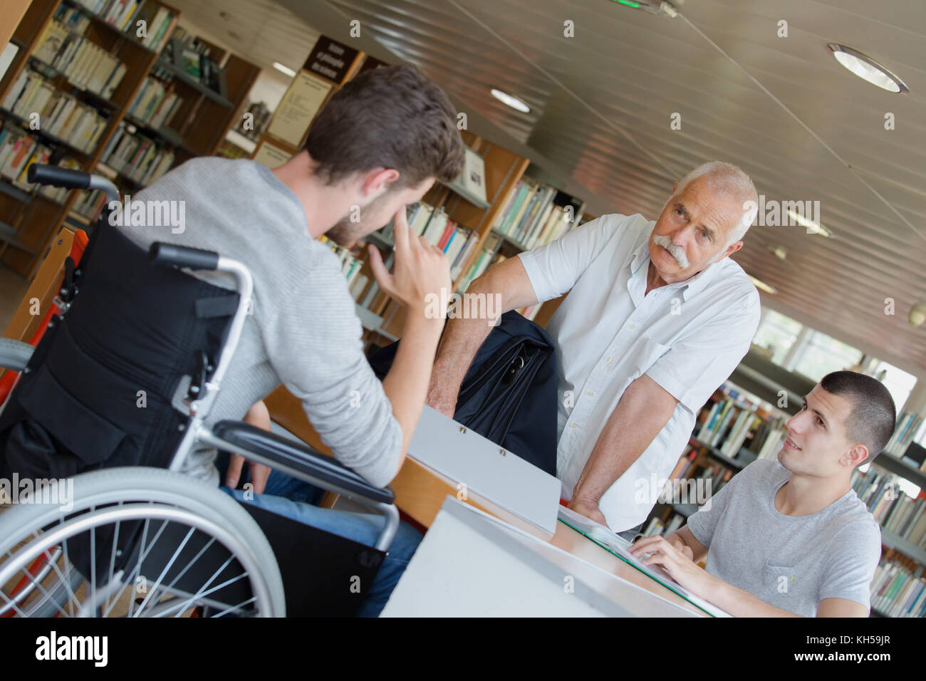teacher helping students out in the library Stock Photo - Alamy